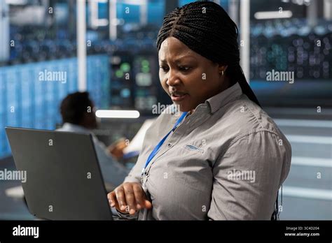 System Administrator In Server Room Using Laptop To Implement And