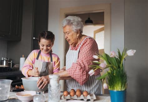 Grandmother With Grandaughter Preparing Traditional Easter Meals