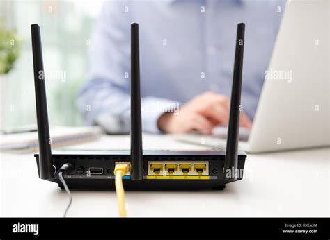 Wireless Router And Man Using A Laptop In Office Router Wireless Broadband Home Laptop Computer