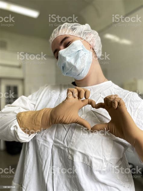 보호 의료 마스크와 장갑을 착용 한 긍정적 인 여성 의사는 손으로 심장을 보여줍니다 40 44세에 대한 스톡 사진 및 기타 이미지 40 44세 건강관리와 의술 구급