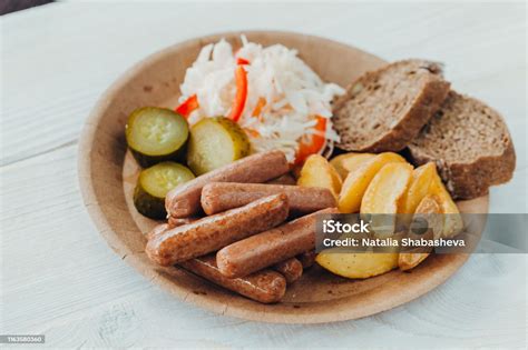 Ntasty 소시지 튀김 감자 오이 양배추와 클로브 나무 테이블에 종이 접시에 테이크아웃 길거리 음식 갈색에 대한 스톡 사진 및 기타 이미지 Istock