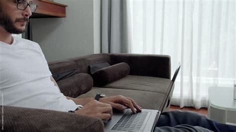 Freelancer Working At Home On Sofa By Stocksy Contributor Jovo