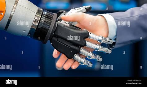 Hand Of A Businessman Shaking Hands With A Droid Robot The Concept Of Human Interaction With