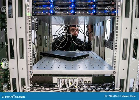 A Man In A Mask Unravels Communication Cable Internet Hacker Switches The Wires In The Server