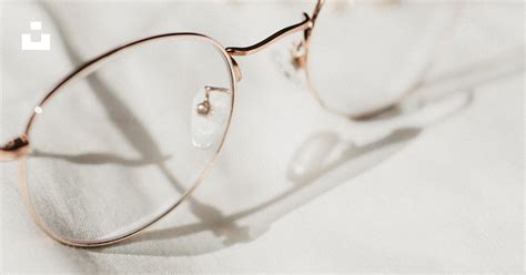흰색 직물에 실버 프레임 안경 사진 Unsplash의 무료 안경 이미지