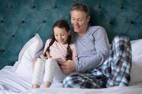 Livro De Leitura Do Pai E Da Filha Na Cama Foto De Stock Imagem De