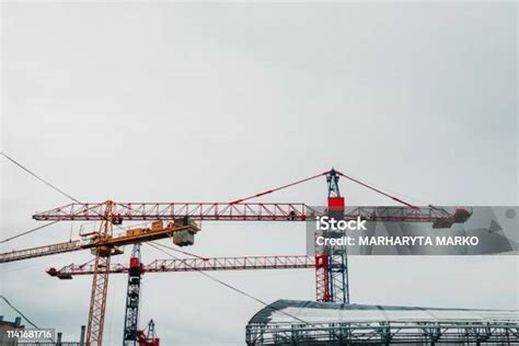 건설 현장 배경에서 미완성 높은 상승 건물과 푸른 하늘을 가진 큰 산업 타워 크레인 비 계 현대 토목 공학 현대 도시 풍경입니다