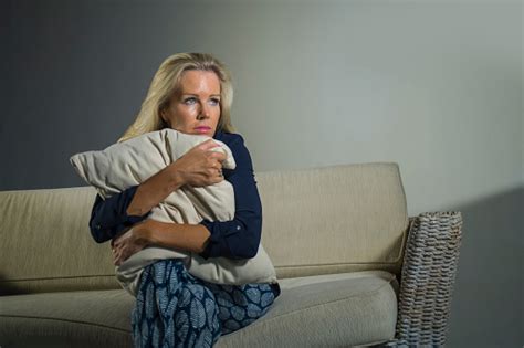 우울 하 고 불안 우울증과 통증 느낌 집에서 소파에 앉아 좌절 고통 하는 아름 다운 금발의 여 자가 슬 프 고 절망적 인 지주