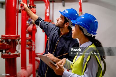 두 명의 엔지니어 또는 기술자 근로자가 건설 현장의 적색 파이프 시스템에 대해 논의하여 문제를 함께 유지 관리하고 해결합니다 기술자에 대한 스톡 사진 및 기타 이미지