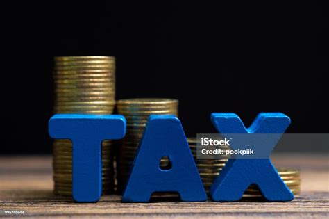 세금 개념입니다 어두운 배경 사업 및 금융 개념에 나무 작업 테이블에 동전의 스택과 함께 세금 알파벳 개념에 대한 스톡 사진 및 기타 이미지 Istock