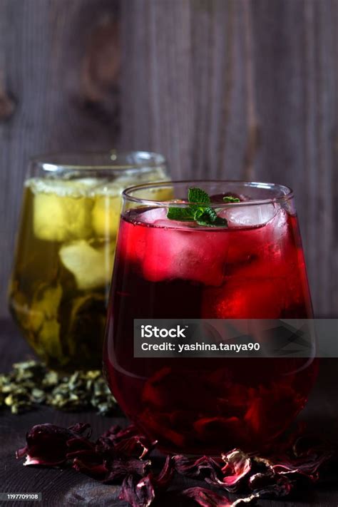 나무 테이블에 아이스 레드 히비스커스 차와 마른 꽃 의 유리 건강한 라이프 스타일 어두운 나무 배경에 민트 잎아이스 그린 허브 차 의 유리 차가운 음료 수직 방향 0명에