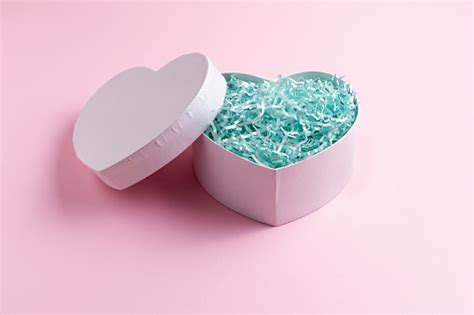 파스텔 핑크 배경에 파란색 종이 필러로 가득 찬 화이트 하트 모양 의 선물 상자 가득 찬에 대한 스톡 사진 및 기타 이미지