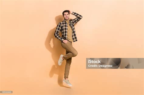 베이지 색 파스텔 색상 배경에 고립 된 재미를 가지고 포즈를 취하는 매력적인 쾌활한 남자의 전체 길이 몸 크기보기 갈색 머리에 대한 스톡 사진 및 기타 이미지 Istock
