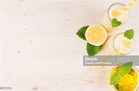 갓 빨 대 민트 잎 레몬 꿀 평면도 잘라와 유리 항아리에 노란색 레몬 스무디 혼합 화이트 나무 보드 배경 공간을 복사 합니다 0