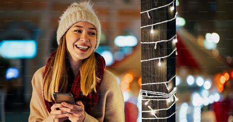 축제 크리스마스 공정한 배경을 가진 도시에서 스마트 폰을 사용 하 여 행복 한 아름 다운 젊은 여자 소녀 사진 Unsplash의 여자 전화 이미지