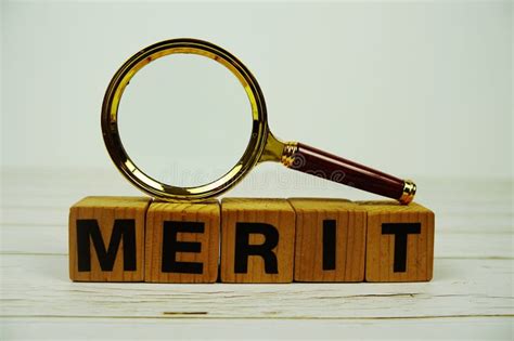 Merit Demerit With Wooden Blocks Alphabet Letters And Magnifying Glass On Wooden Background
