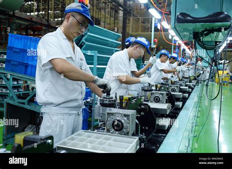 Chinese Factory Workers Assemble Motorcycles On The Assembly Line At