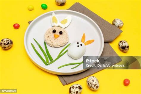 부활절 재미 창조적 인 건강한 아침 식사 점심 음식 아이디어 어린이 어린이 토끼 삶은 닭 계란 빵 껍질을 벗긴 당근 접시 노란색 테이블 배경에 채소로 만든 토끼 상단 보기