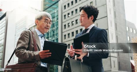 문서 개발 또는 건물을 위한 도시의 계획 팀워크 및 사업가 개발자 도시 계획가 성숙한 일본인 전문직 동료들이 함께 프로젝트에 대해 이야기합니다 2명에 대한 스톡 사진 및