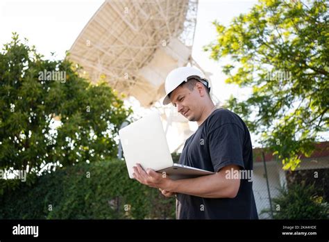 Engineer Testing Earth Based Astronomical Radio Telescope Use Laptop
