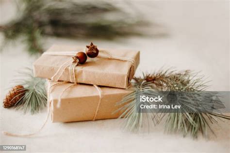 황마 로프 붉은 열매 소나무 콘이 있는 갈색 재활용 종이로 싸여 있는 겨울 휴가 선물 크리스마스 선물 크리스마스 트리에 대한