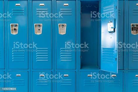 전형적인 미국 고등학교의 뚜렷하지 않은 복도를 따라 빈 파란색 금속 사물함을 하나씩 엽니 다 식별 가능한 정보가 포함되어 있지
