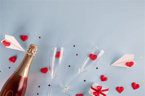 발렌타인 데이 배경입니다 선물 상자 알람 시계 빨간 사탕 마음과 종이 비행기 파스텔 블루 배경에 두 개의 샴페인 안경 발렌타인