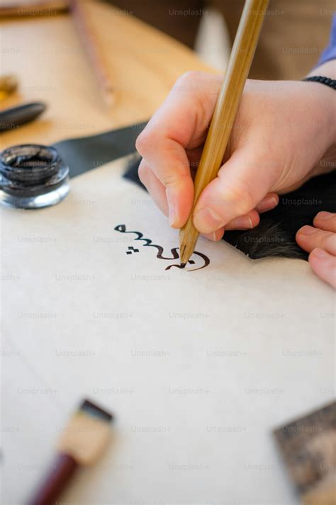 연필로 종이에 쓰는 사람 사진 Unsplash의 아랍어 서예 이미지