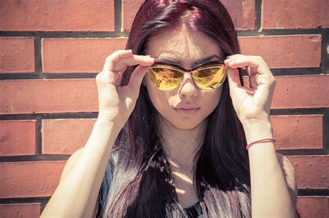 벽돌 벽 옆에서 포즈를 취하는 선글라스를 쓴 아름다운 여성 갈색 머리에 대한 스톡 사진 및 기타 이미지 갈색 머리 검은색