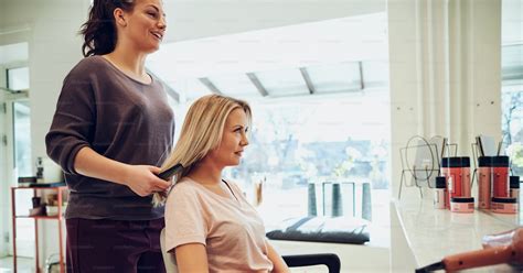 미용실 의자에 앉아 웃고 있는 젊은 금발 여자는 미용사와 약속하는 동안 머리를 다듬고 있다 사진 Unsplash의 앉아 이미지