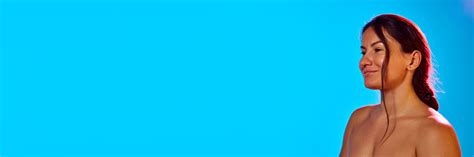 기치 네거티브 공간이 있는 푸른 배경에 네온 불빛으로 포즈를 취하는 벌거벗은 어깨를 가진 긍정적이고 웃는 여자의 측면도 35