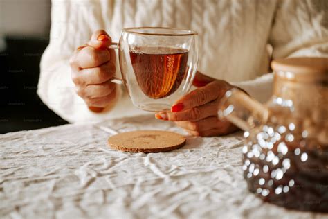 차 한 잔을 들고 테이블에 앉아있는 여자 사진 Unsplash의 찻잔 이미지