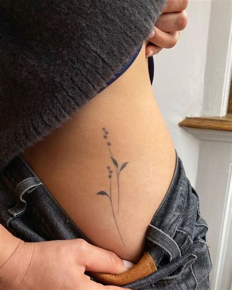 Small And Elegant Flower Tattoo On Lower Back Leaves Tattoo Lower