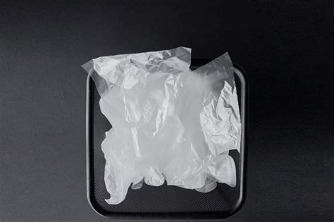 손잡이가달린 비닐 봉지 검은 색 배경의 쓰레기통에 장갑 재활용을 위해 비닐 봉투를 사용했습니다 개념 플라스틱 셀로판 폴리에틸렌과 생태 행성 오염 0명에 대한 스톡 사진 및