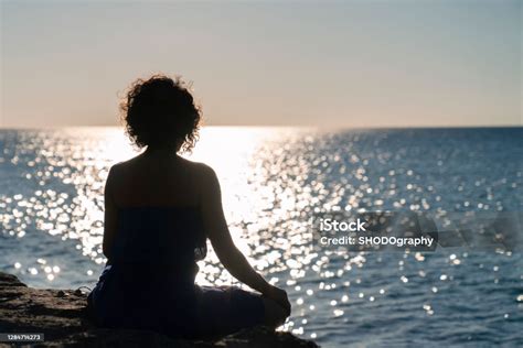 건강한 라이프 스타일과 요가 개념 클로즈업 핸즈업 여자는 연꽃 위치에서 일출에서 야외에서 요가를합니다 아침에 운동하고 명상하는