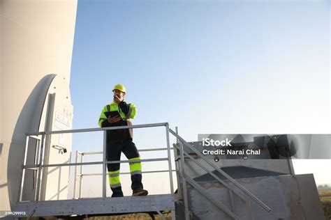 제복을 입은 남성 유지 보수 기술자가 토키와 디지털 태블릿을 사용하여 발전소 풍력 터빈에서 작업하고 있습니다 탄소 중립과 청정