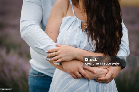 보라색 라벤더 꽃밭에서 포옹하는 커플 남자와 여자는 서서 꽃 숲 사이의 빈터 여름의 자연을 즐긴다 해질녘에 걷는 사랑하는 가족