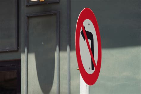 도시 담에 붙은 파란색 좌회전 교통 표지판 · 무료 스톡 사진