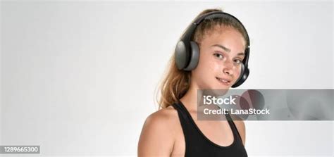헤드폰을 쓰고 음악을 듣고 흰색 배경에 고립된 포즈를 취하는 동안 카메라를 바라보는 귀여운 스포츠 소녀 아이의 초상화 169에 대한 스톡 사진 및 기타 이미지 Istock