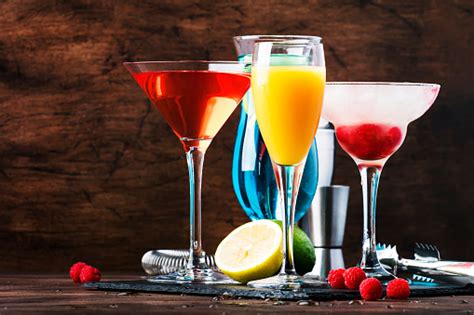 엄선된 여름 칵테일 차가운 상쾌한 알코올 음료 및 음료 미모사 코스모탄 라즈베리 마가리타 블루 하와이 바 도구가 있는 나무 바 카운터 감귤류 과일에 대한 스톡 사진 및 기타