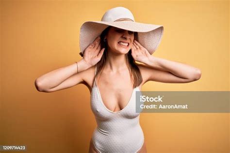 젊은 아름 다운 갈색 머리 여자 휴가 착용 수영복과 여름 모자 귀 제스처에 두 손을 듣고 하려고 험담에 대 한 호기심 청각 문제 청각 장애인 갈색 머리에 대한 스톡 사진 및