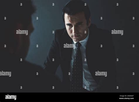 Detective Interviewing Suspect Or Criminal Man In Interrogation Room