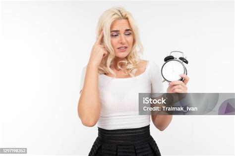 흰색 티셔츠를 입은 흰 머리를 한 소녀는 고립된 흰색 배경에 알람 시계를 들고 늦게 있을 까봐 걱정합니다 25 29세에 대한 스톡 사진 및 기타 이미지 Istock