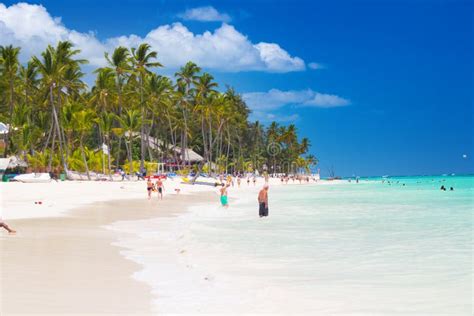 People Walking Along The Coastline And Sunbathing On One Of The Best