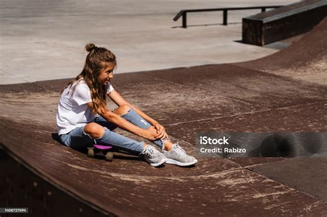 페니 보드에서 넘어진 후 활동적인 어린이 소녀가 부상을 입었고 스케이트 파크 놀이터에서 스포츠 경사로에 앉아서 고통을 느낍니다 10 11세에 대한 스톡 사진 및 기타 이미지