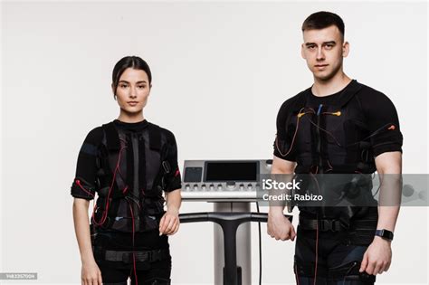 전기 근육 자극 슈트에서 스포츠 훈련 Ems 정장을 입은 남자와 여자는 흰색 배경에 근육을 자극하기 위해 전기 충격을 사용한다 긴급서비스와 구조 직업에 대한 스톡 사진 및