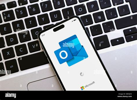 Mobile Phone Over A Laptop Keyboard Opening Outlook App For Mail Of Microsoft Rosario