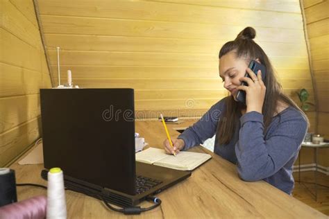 Woman Fashion Designer Working On A Laptop Making Notes In A Notebook Stock Image Image Of