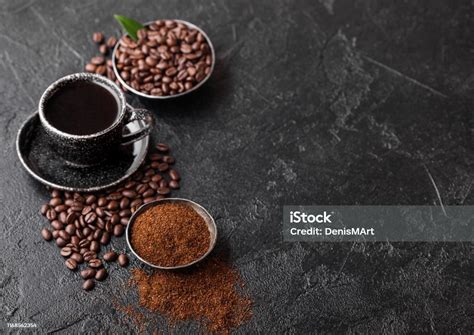 검은 배경에 커피 나무 잎을 가진 콩과 분쇄 분말을 곁들인 신선한 생 유기농 커피 컵 맨 위 보기 0명에 대한 스톡 사진 및