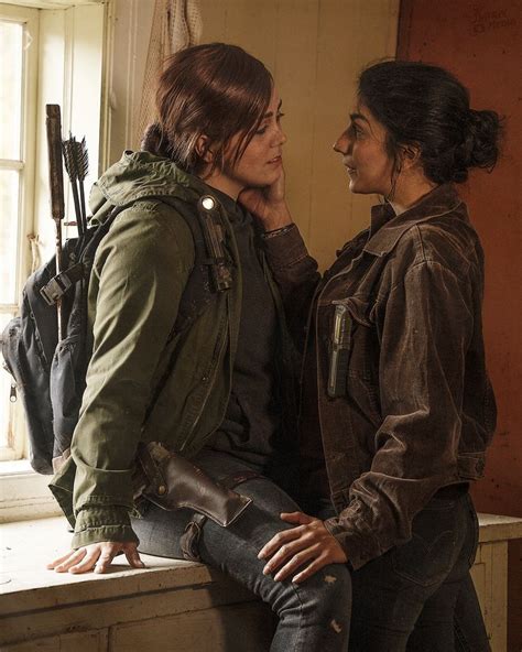 Two Women Standing Next To Each Other In Front Of A Window Looking At Each Other
